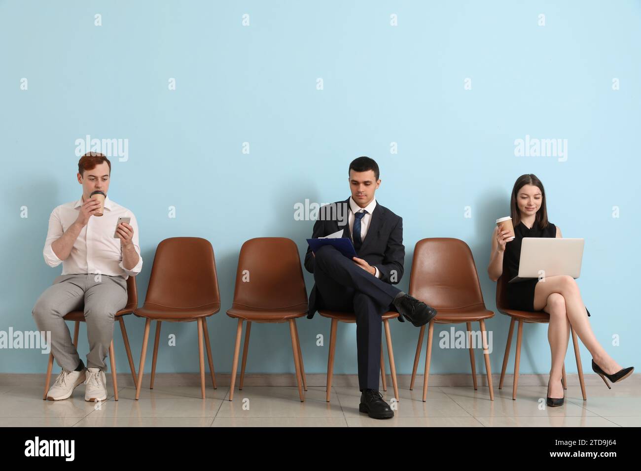 Applicants waiting for job interview near blue wall Stock Photo - Alamy
