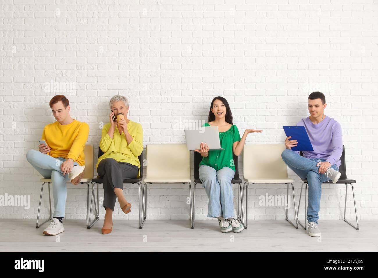 Applicants waiting for job interview near white brick wall Stock Photo ...