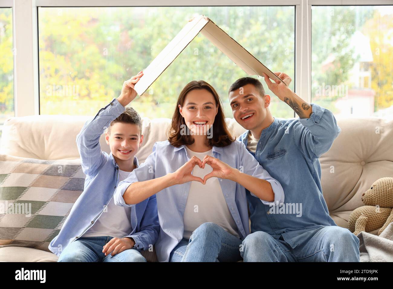 Little boy and his parents with cardboard paper making heart gesture at ...