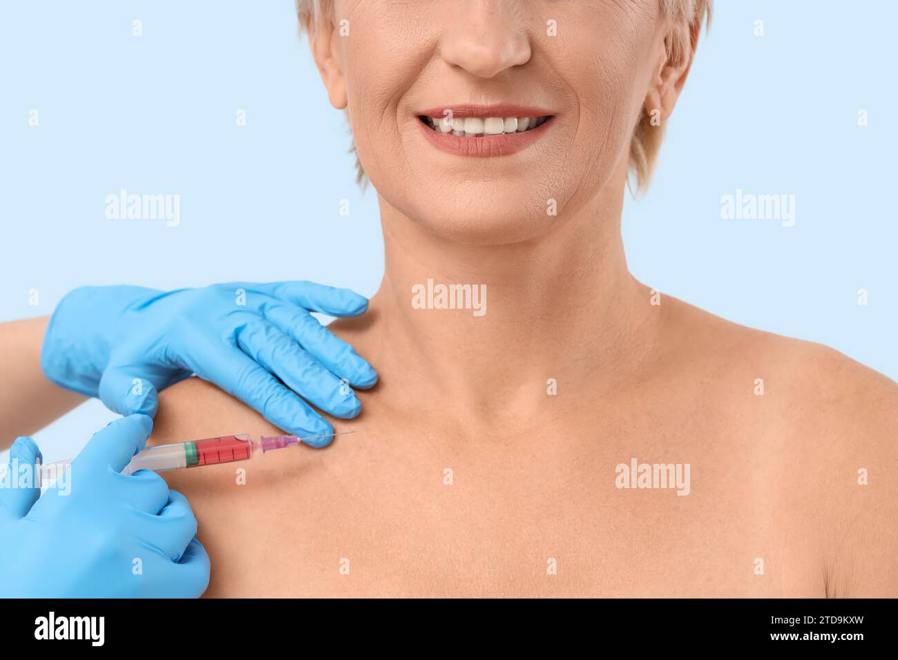 Beautiful mature woman receiving injection on pink background, closeup ...