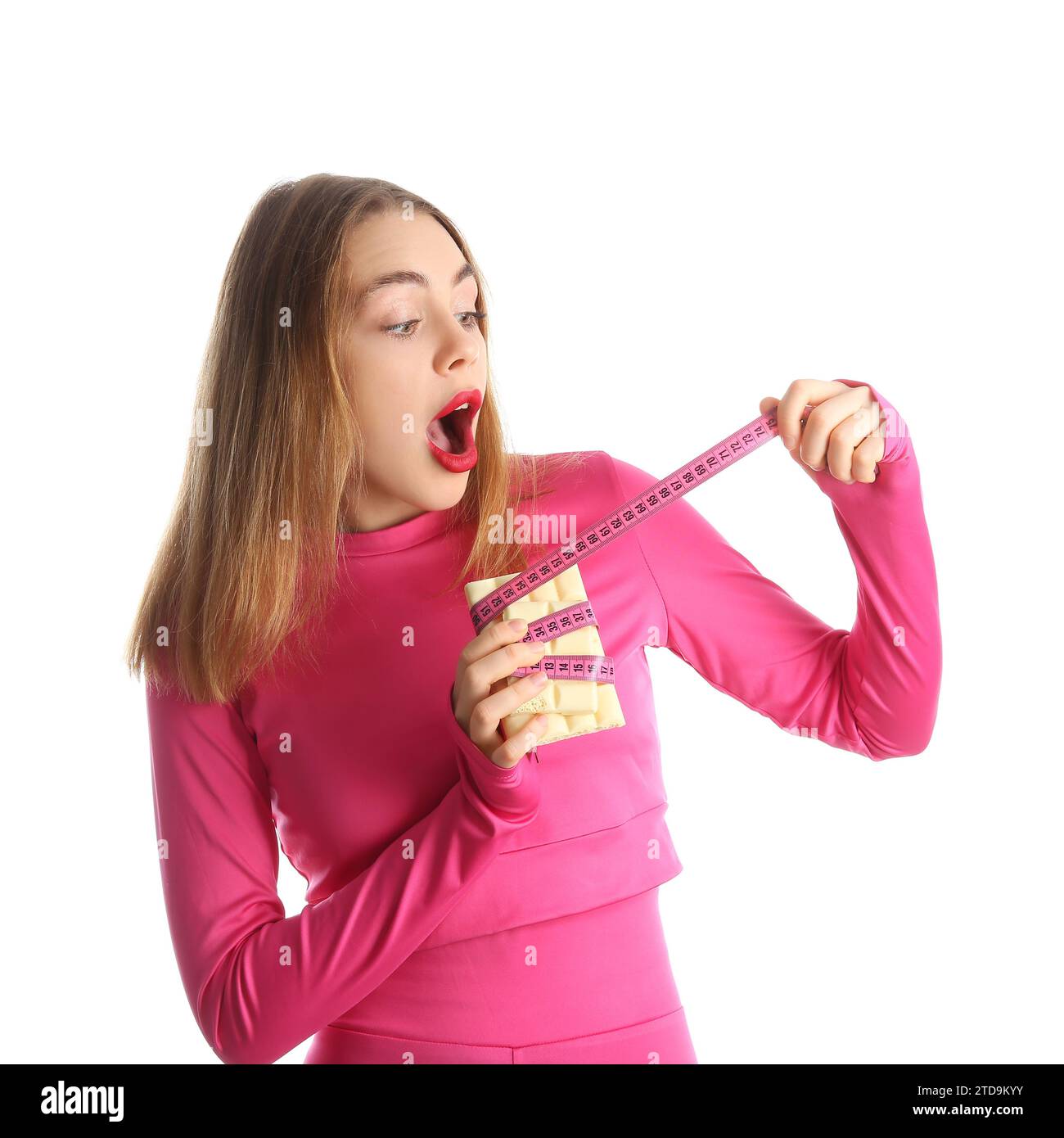 Shocked young woman with white chocolate bar and tape measure on light ...