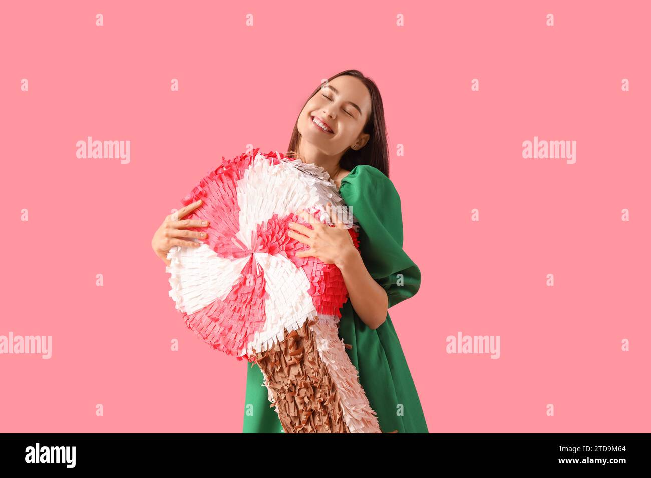 Beautiful woman with candy pinata on pink background Stock Photo - Alamy