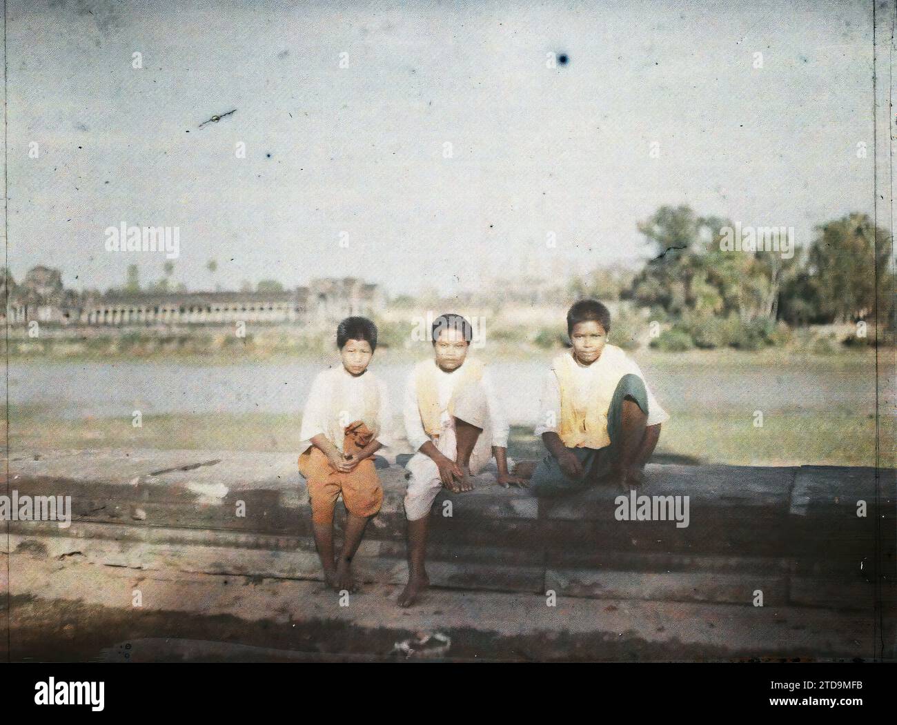Angkor, Cambodia, Indochina Children sitting on the edge of the moat ...