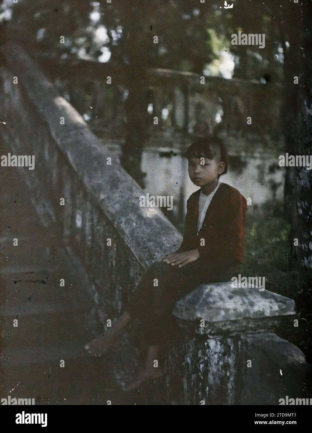 Tonkin, Indochina A little girl sitting at the bottom of a staircase ...