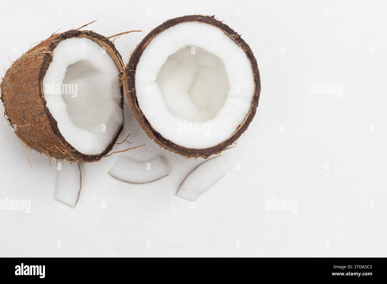 Two halves of fresh coconut. Close up. White background. Copy space ...