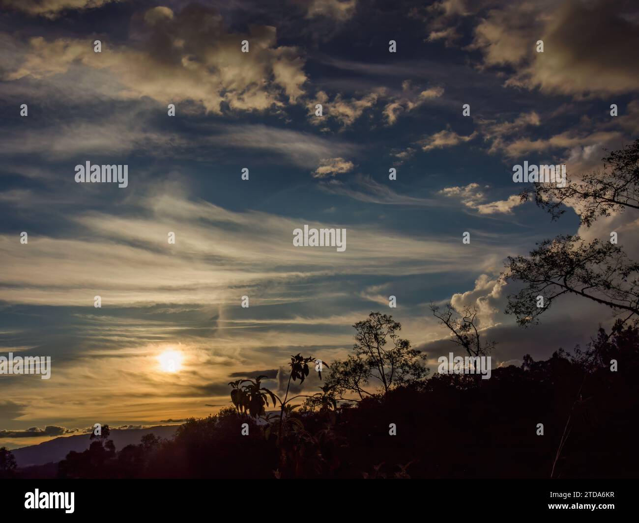 The sun barely hidden behind a translucent cloud in the sunset over the ...