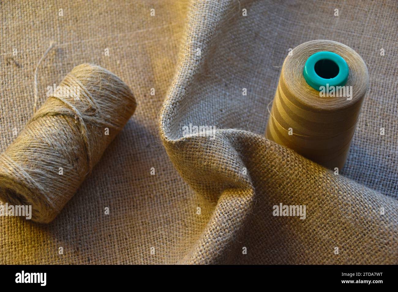 Skeins of thread on crumpled burlap. Yellow threads on coarse cloth ...