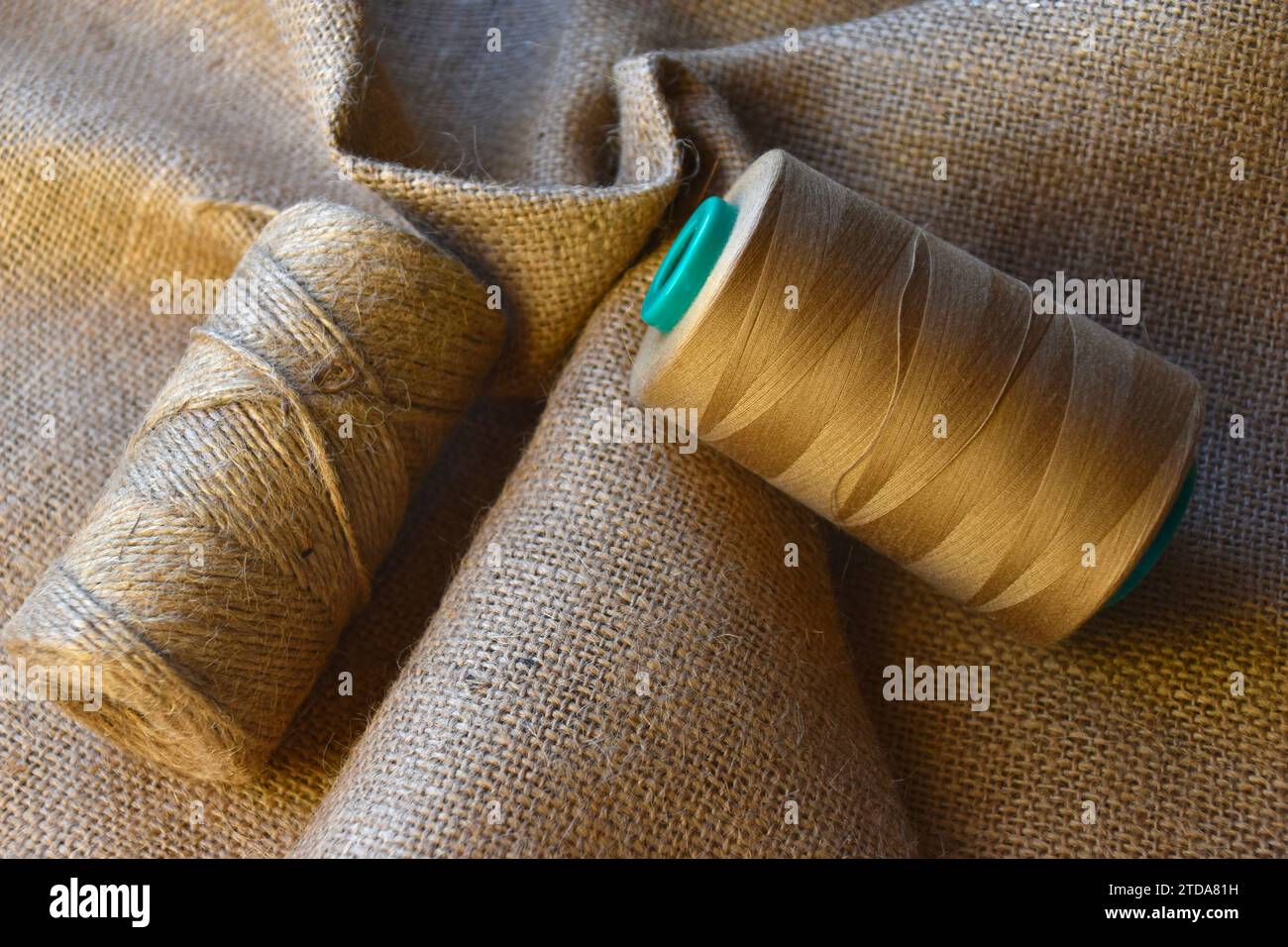 Skeins of thread on crumpled burlap. Yellow threads on coarse cloth ...