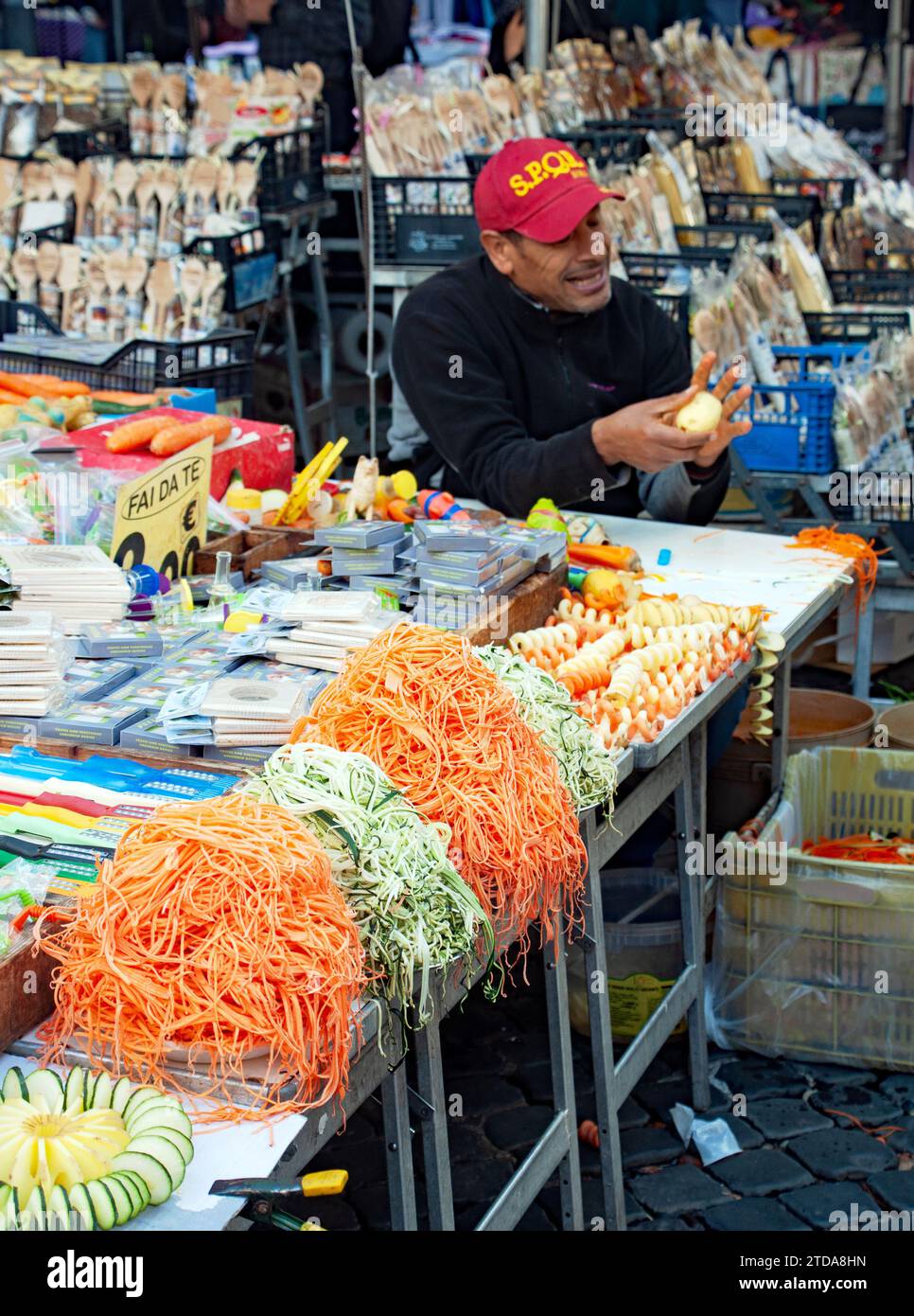 Vendor demonstrates a vegetable tool at a booth in Campo de' Fiori ...