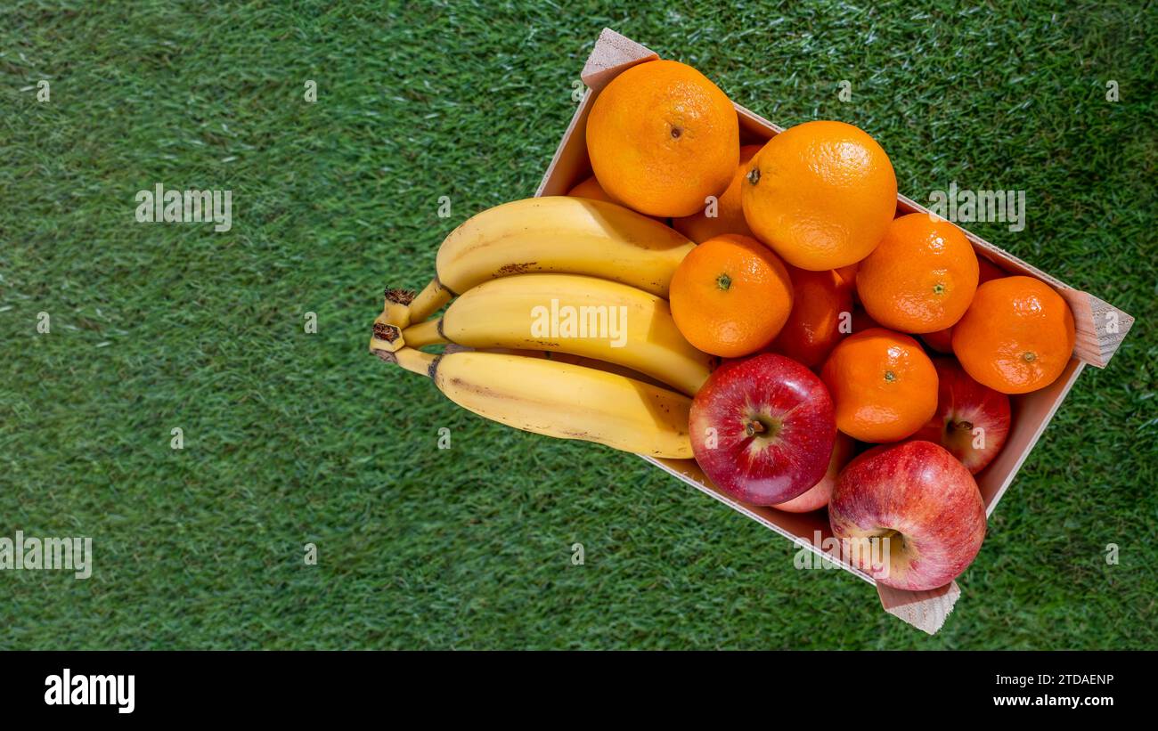 wooden fruit crate on grass with different fruit apple orange banana ...