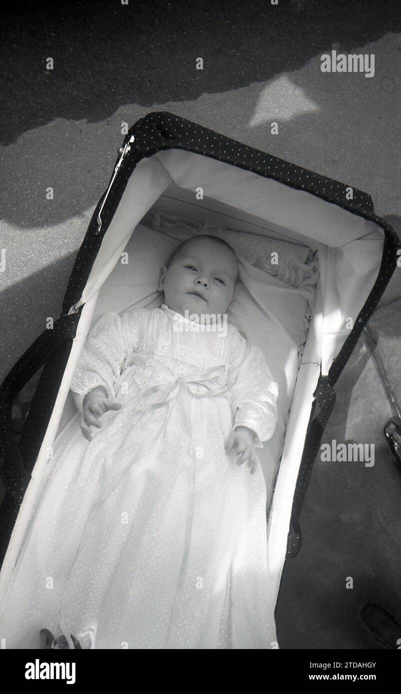 1960s, historical, view from above of a baby in a lace christening gown ...
