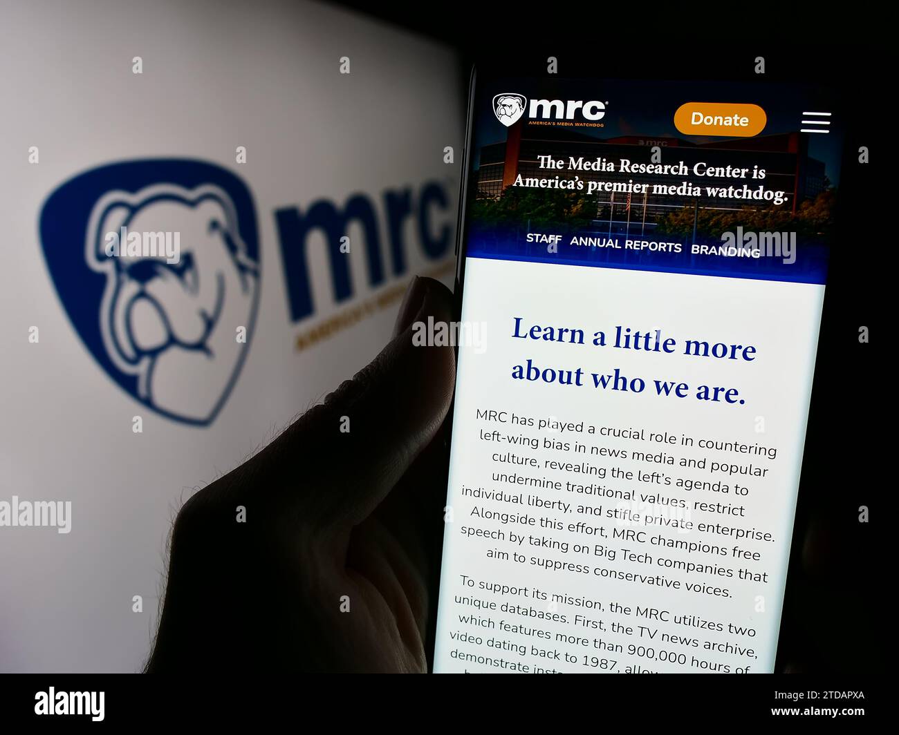 Person holding smartphone with webpage of watchdog organisation Media Research Center (MRC) in ...