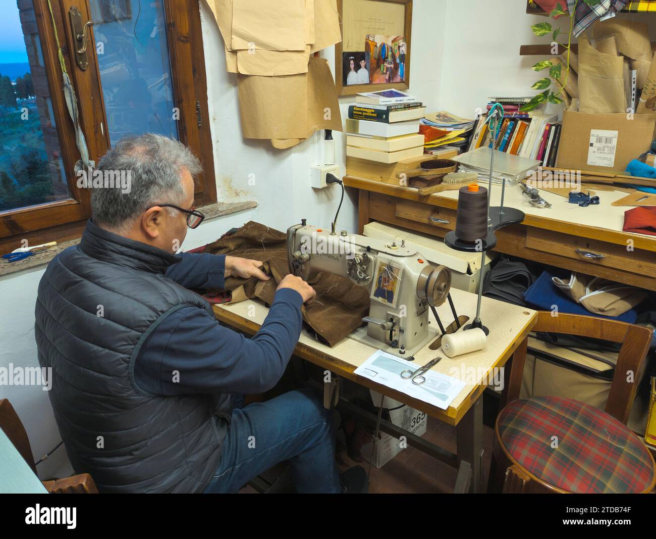 The tailor sews a velvet jacket, Tuscan artisan tailoring, high fashion ...