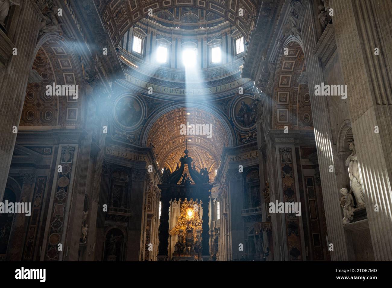 View of St. Peter’s Basilica interior with rays of light falling on ...