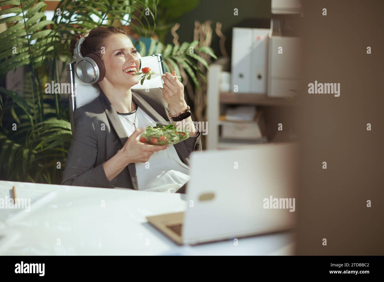 Sustainable workplace. smiling modern accountant woman in a grey ...
