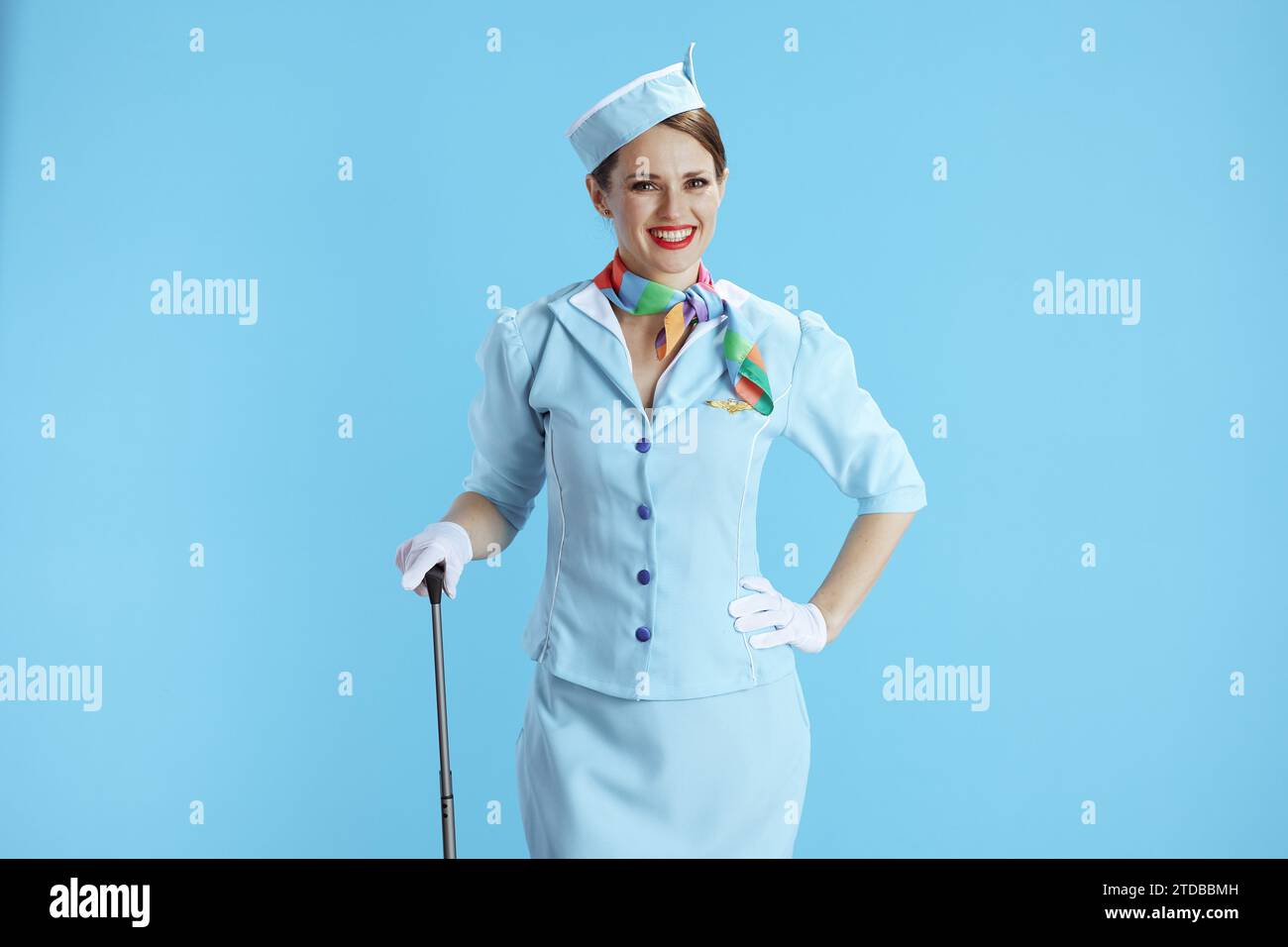 happy stylish female stewardess isolated on blue background in blue ...