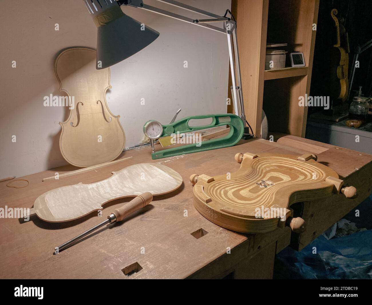 raw new violin top plate and back plate carving on violin maker desk ...