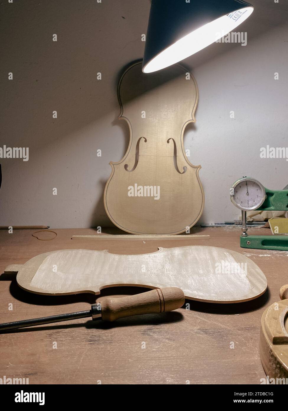 raw new violin top plate and back plate carving on violin maker desk ...