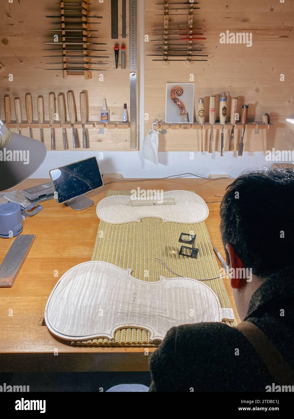 violinmaker performing purfling to new raw violin top plate using loupe ...