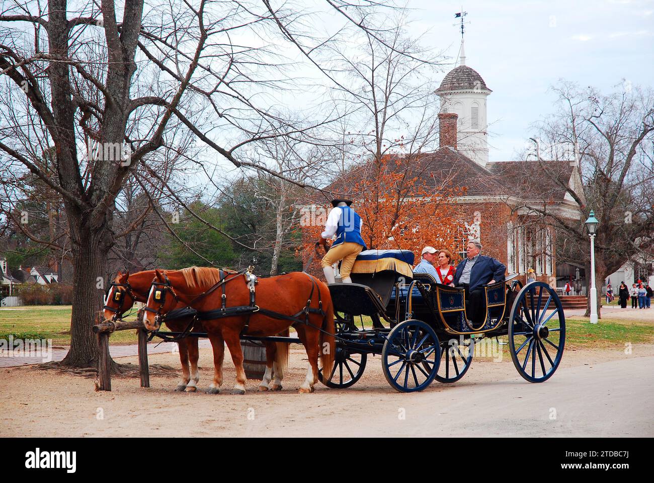 A horse and carriage takes riders on a tour through the Colonial town ...
