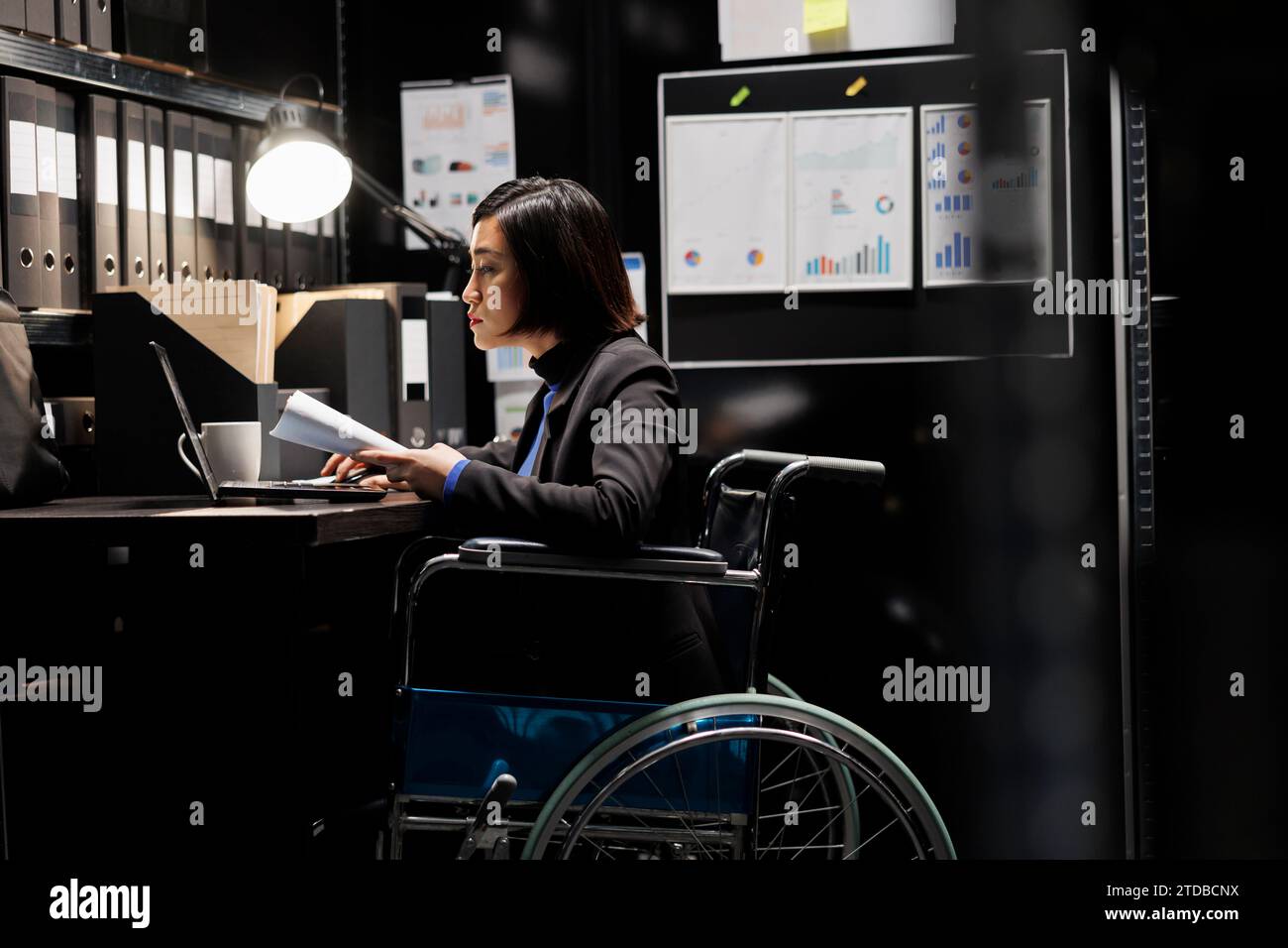 Paralyzed businesswoman employee in wheelchair checking bookkeeping ...