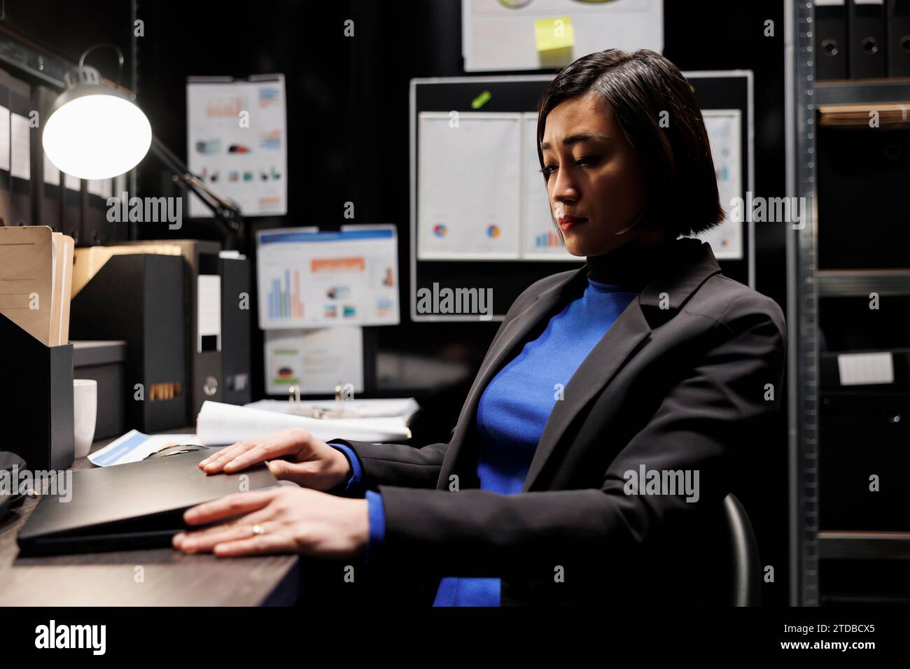 Accountancy asian employee clocking out from work, shutting down laptop ...