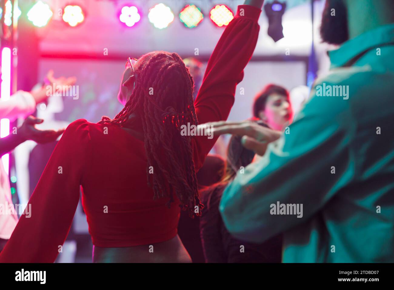 African american woman in red blouse jumping and dancing in crowded ...