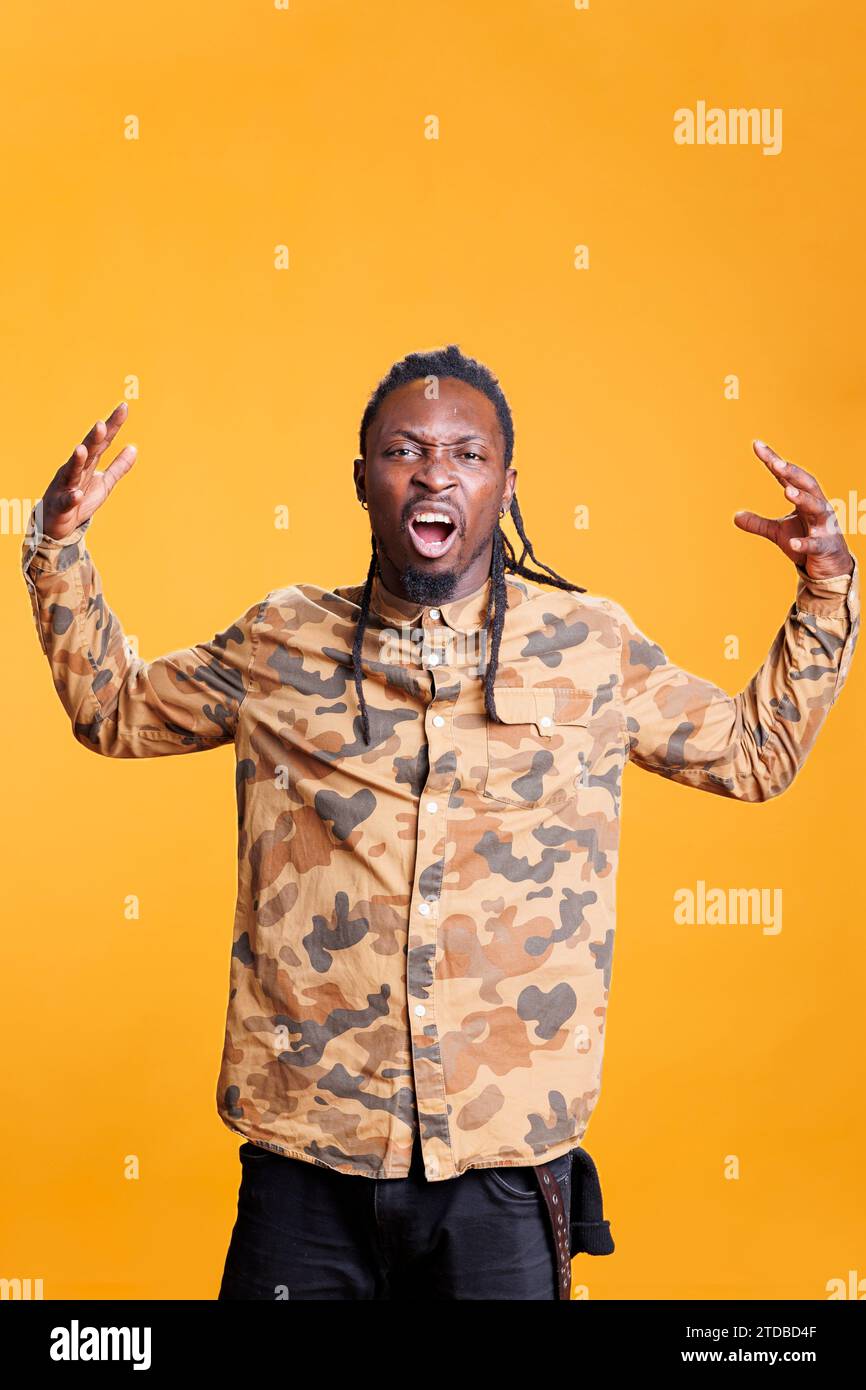 Grumpy young adult having nervous expression on face while standing in ...