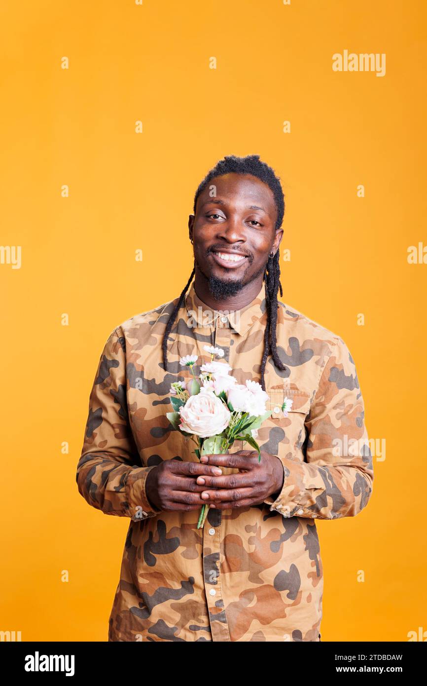 Smiling excited man holding white roses bouquet, presenting surprise ...