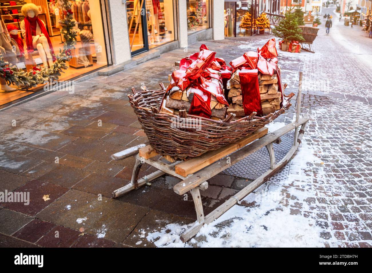 Christmas decorations on an old wooden sledge along a snowy cobbled ...