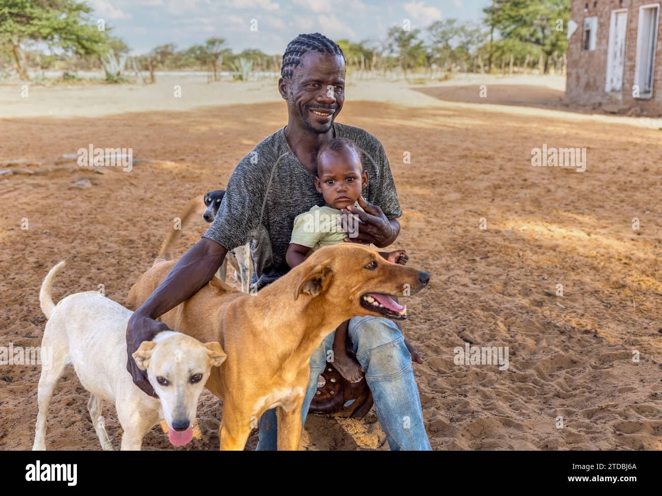 village , african family father and kid together with the dogs at the ...