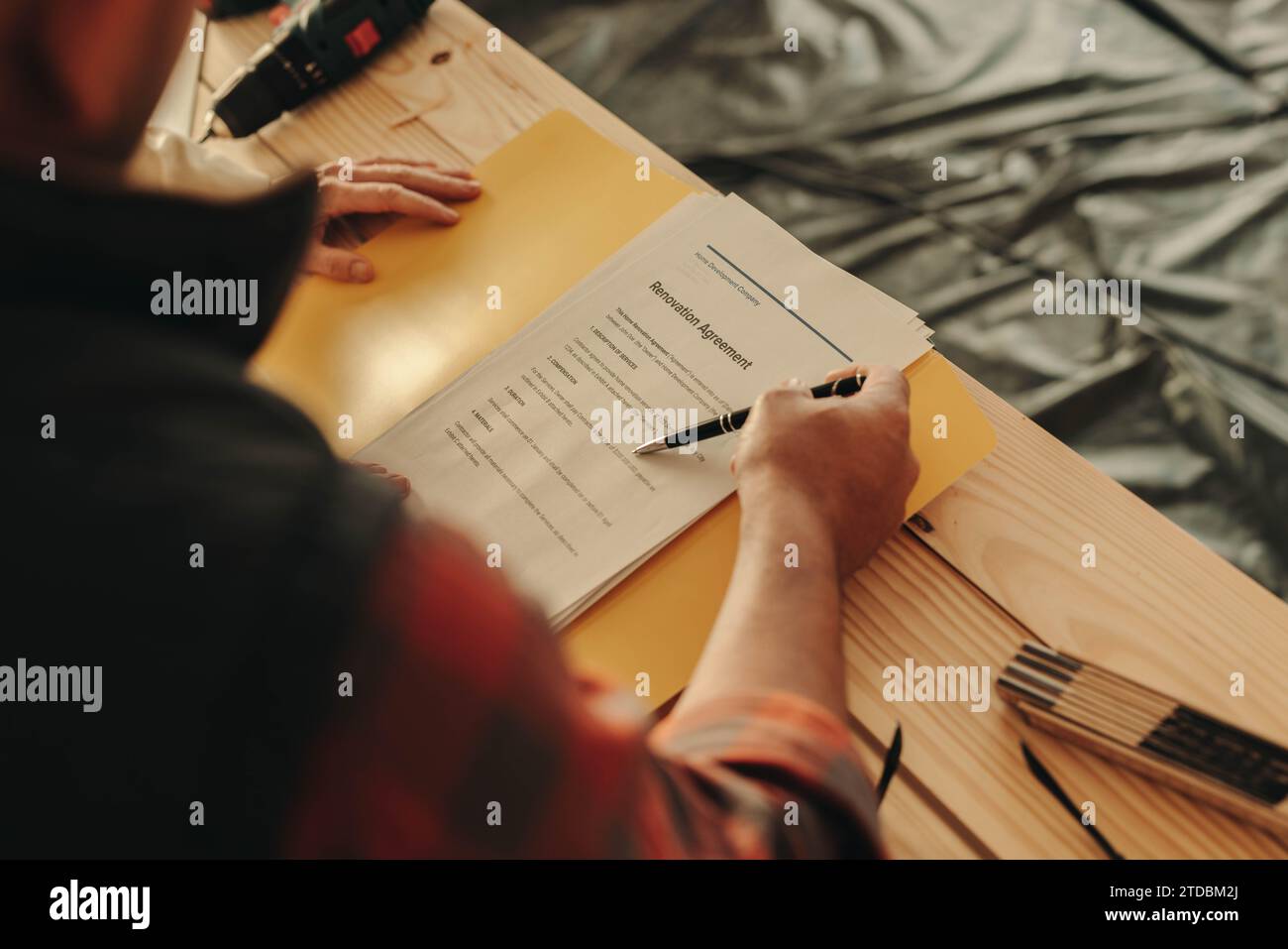 Contractor signing a contract for a home renovation project. He writes ...