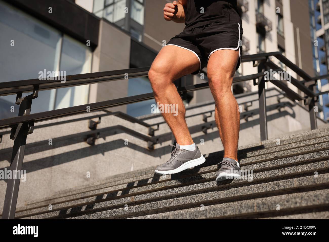 Man running down stairs outdoors on sunny day, closeup. Space for text ...
