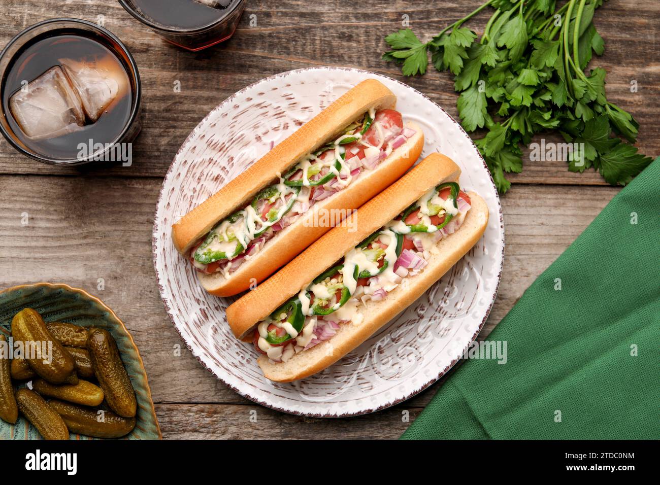 Delicious hot dogs with onion, chili pepper and sauce served on wooden ...