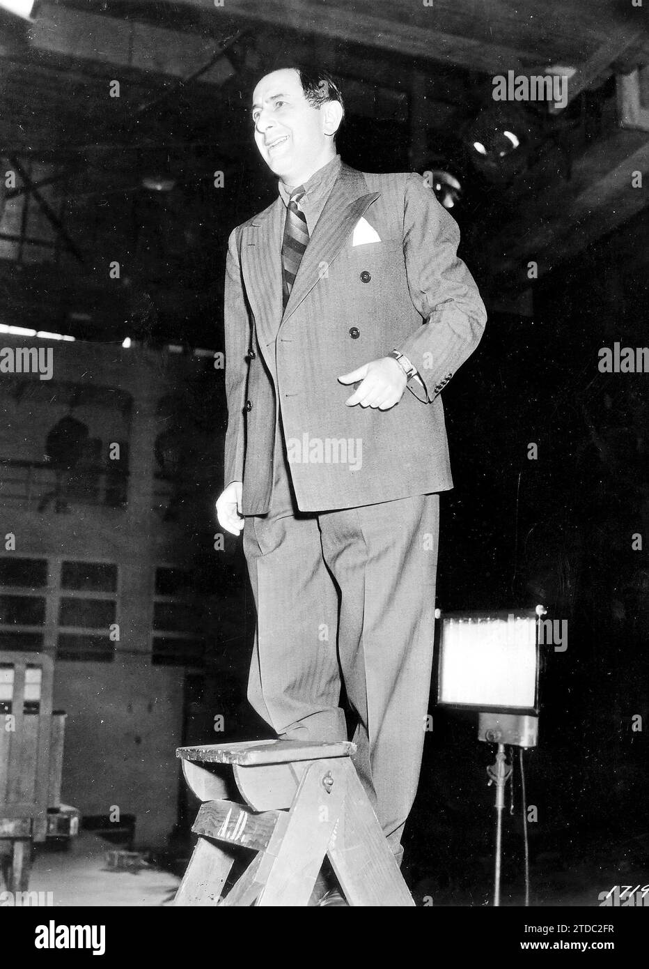12/31/1937. Film director Ernest Lubitsch, climbing a ladder to examine ...