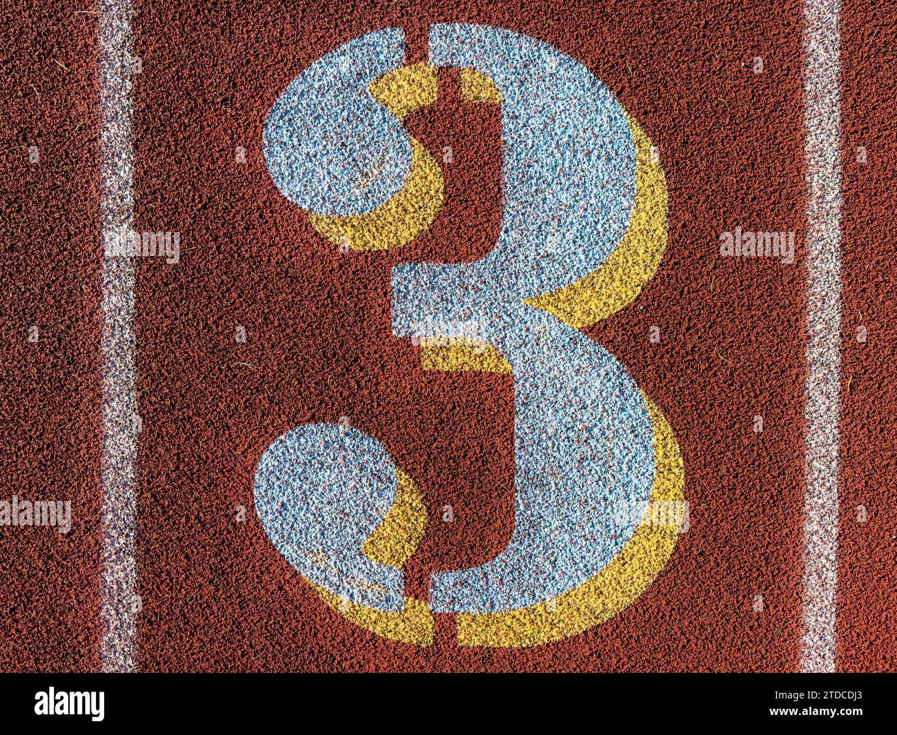 Close up lane number 3 on a new red running track with white lane lines ...