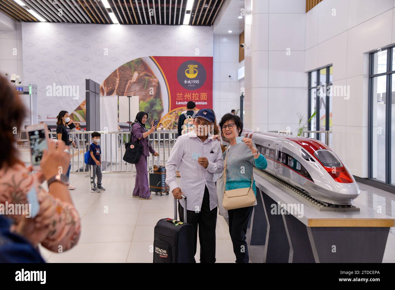 Beijing, Indonesia. 17th Dec, 2023. Passengers pose for photos with a ...