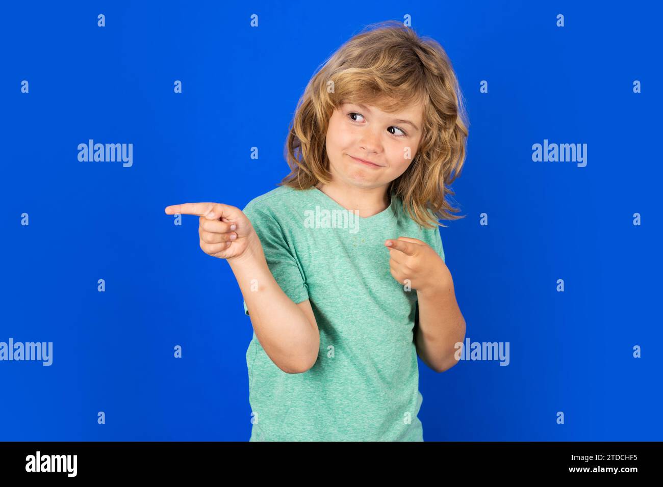 Child boy pointing away on isolated studio background. Kid with index ...