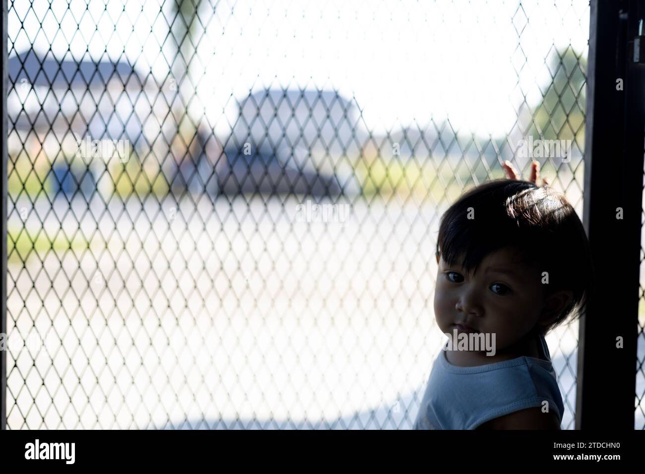 The boy is holding his hands on the fence. The Boy Holds On To The Iron ...