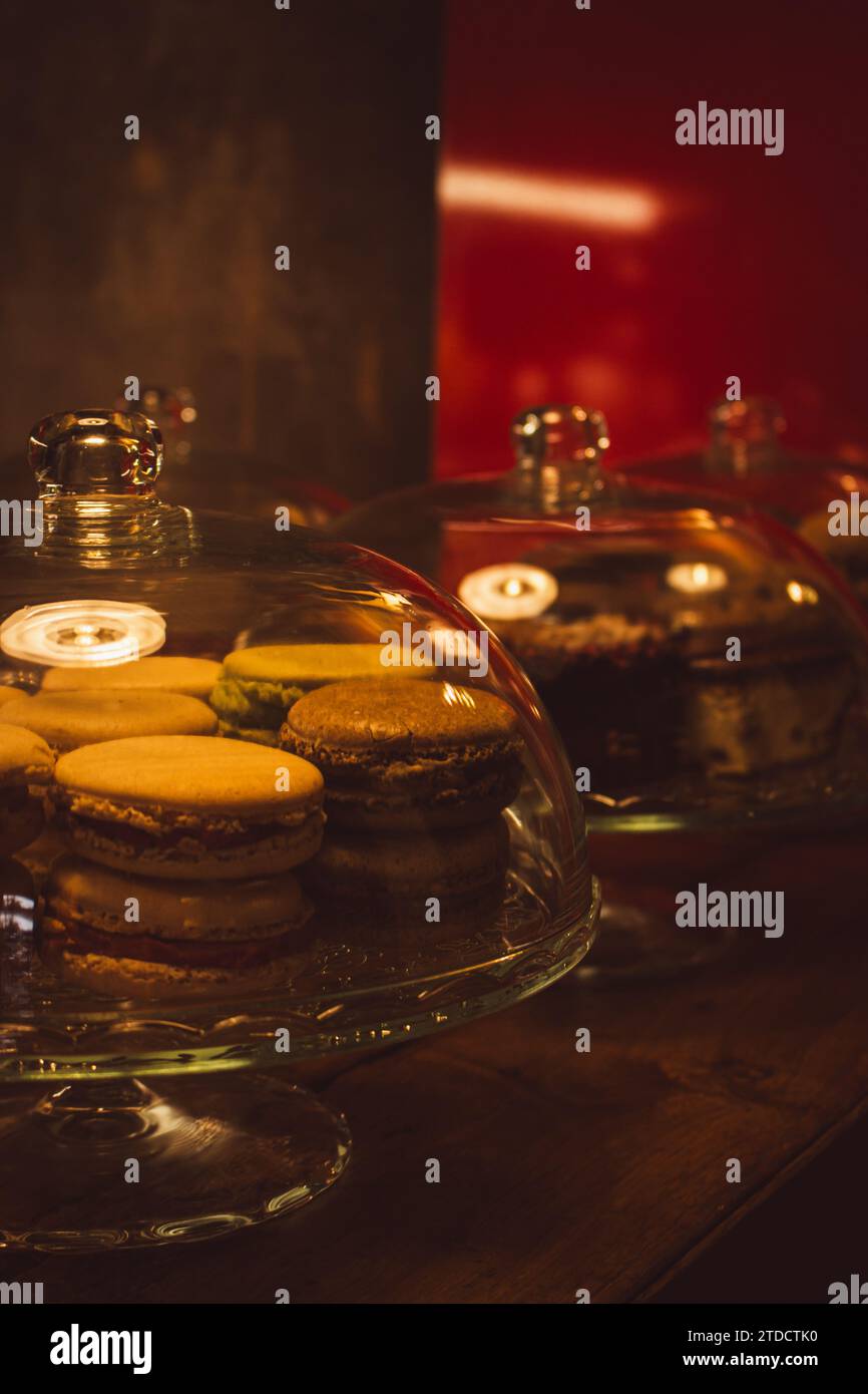 Glass pot with macarons and cakes. Cake shop interior. Cheesecake and ...
