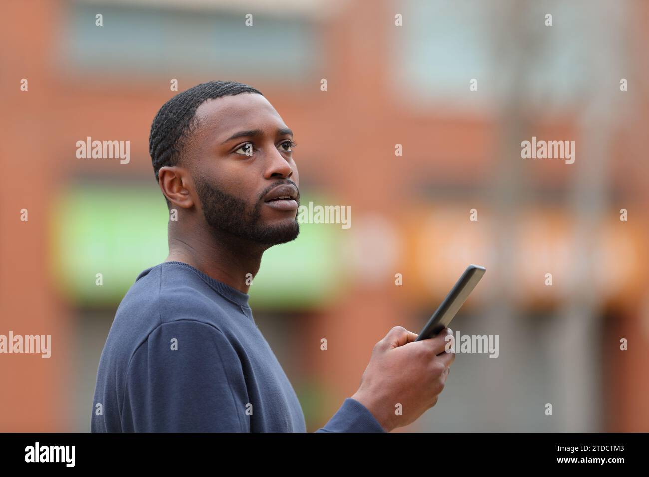 Lost black man searching location on smart phone in the street Stock ...