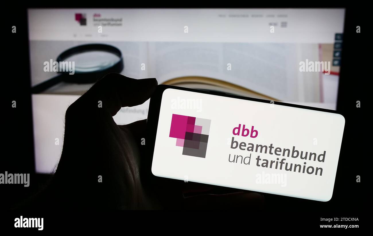 Person holding mobile phone with logo of trade union center DBB ...