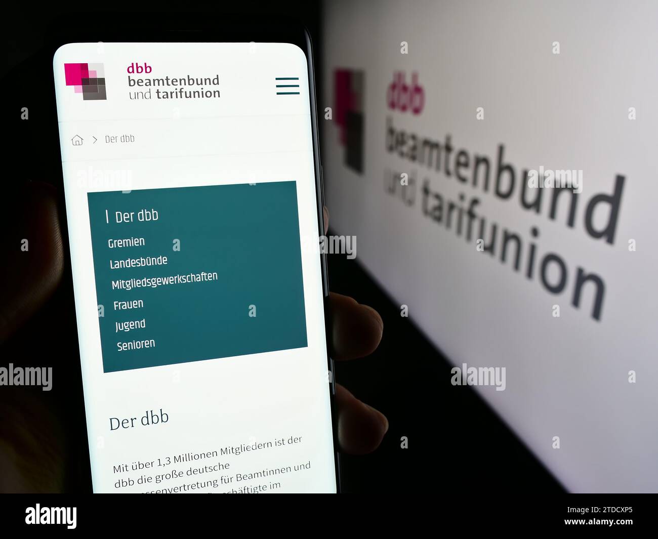 Person holding smartphone with website of trade union center DBB ...