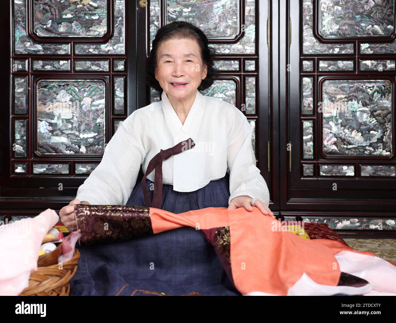 A master of traditional Korean clothing, a Hanbok expert, is sewing for ...