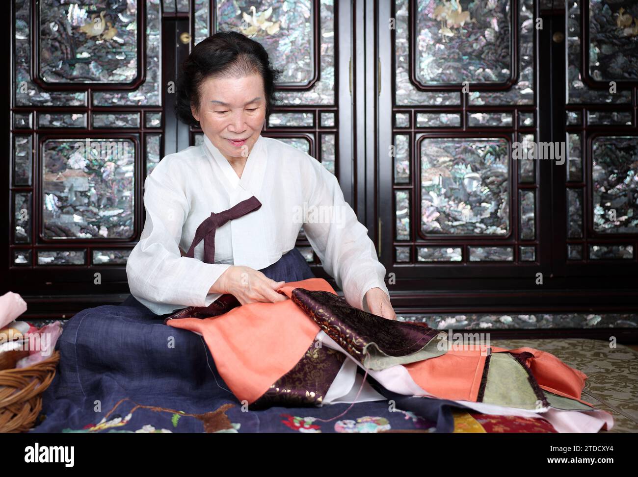 A master of traditional Korean clothing, a Hanbok expert, is sewing for ...