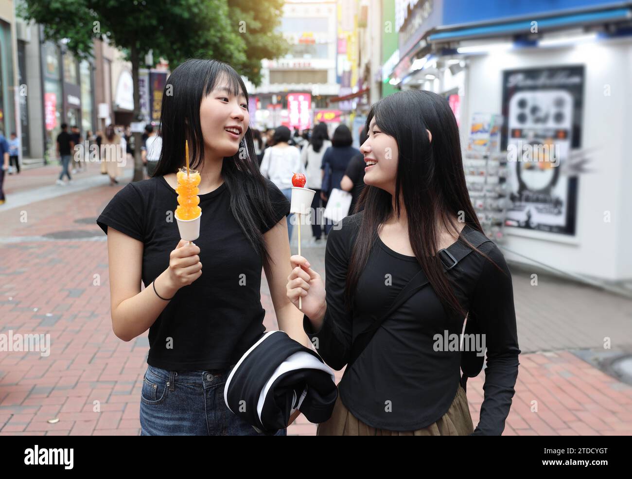 Female students walking while eating Tanghulu, a traditional Chinese ...