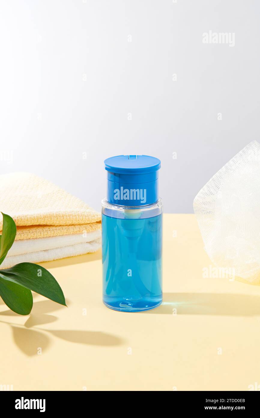 Close-up of a transparent blue bottle of makeup remover standing out on ...