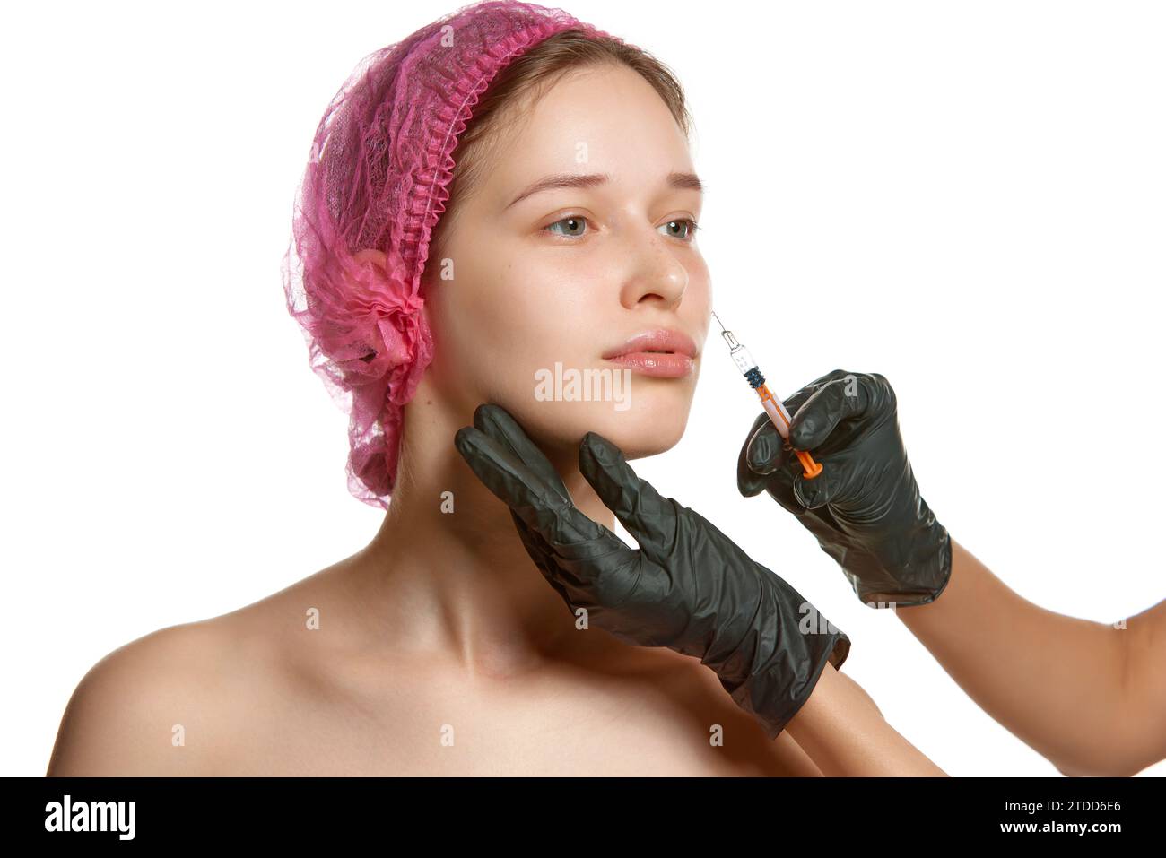 Portrait of beautiful woman in pink cap for cosmetic treatments doing ...