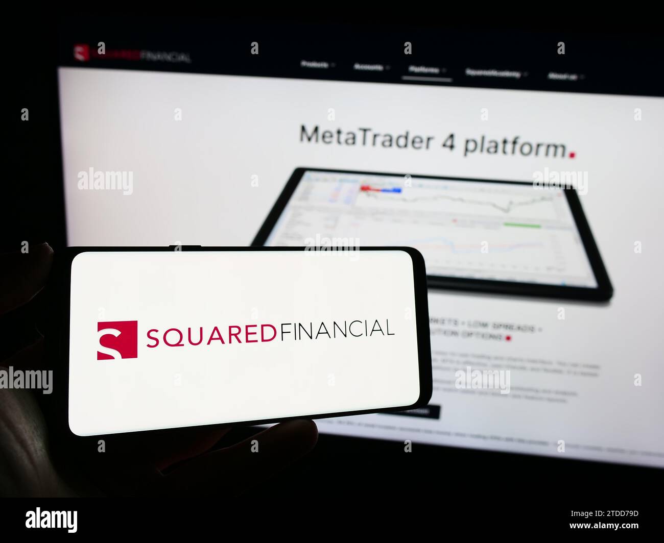 Person holding mobile phone with logo of trading platform company ...