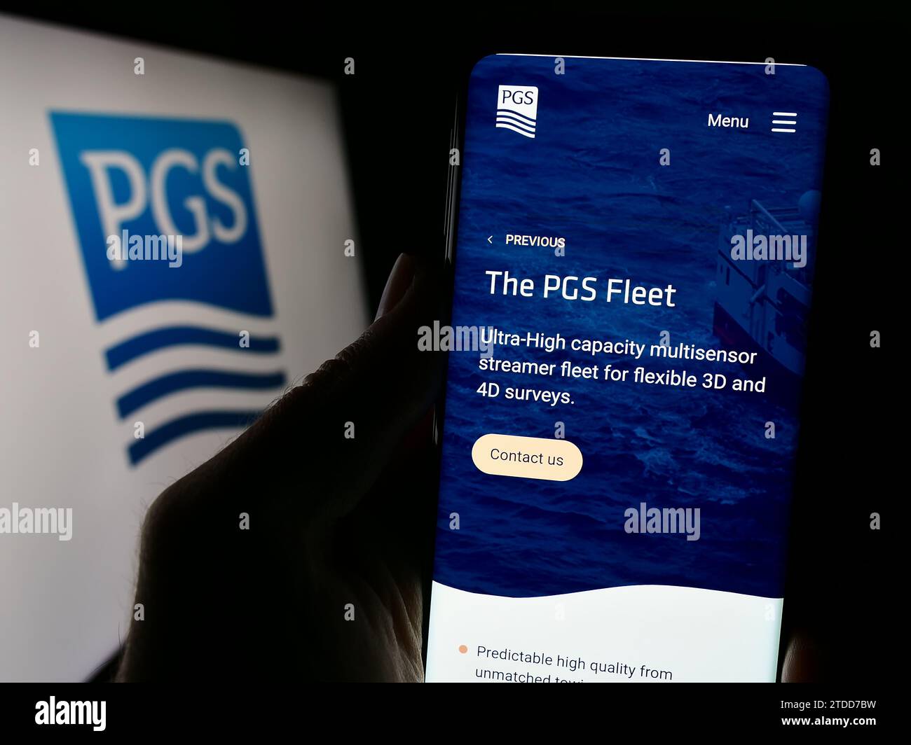 Person holding smartphone with webpage of Norwegian oilfield service ...